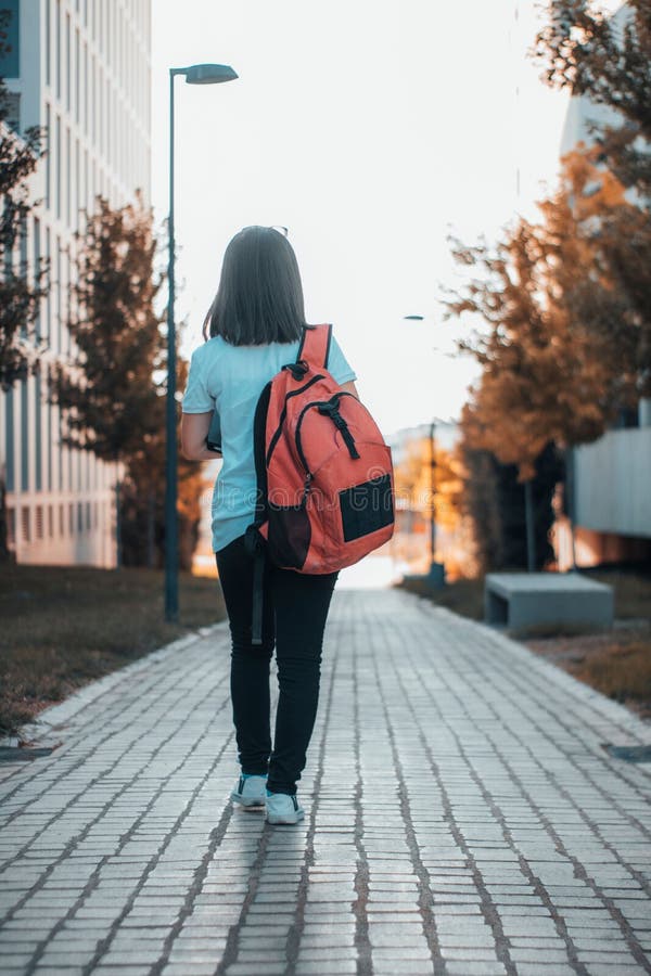 Low-angle Shot of a Woman with a Backpack from Behind Walking on the ...