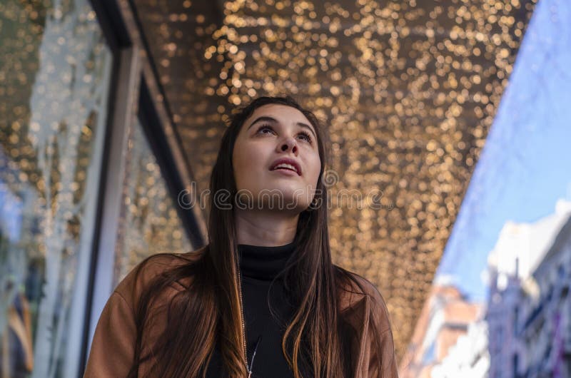Low Angle Shot of a Young Female Looking Up Under Hanging Lights Stock ...