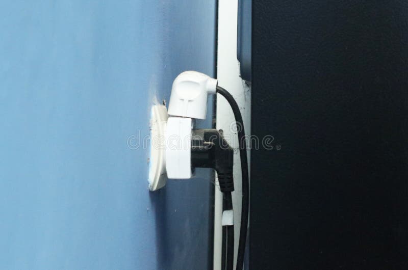 Low Angle Side Profile Shot of a White Electrical Outlet Wedged Behind ...