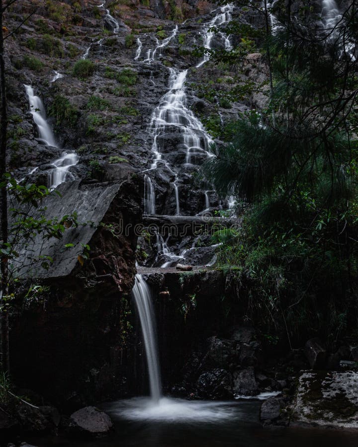 Low Angle Vertical Shot of a Waterfall Pouring Onto a Lake Stock Photo ...