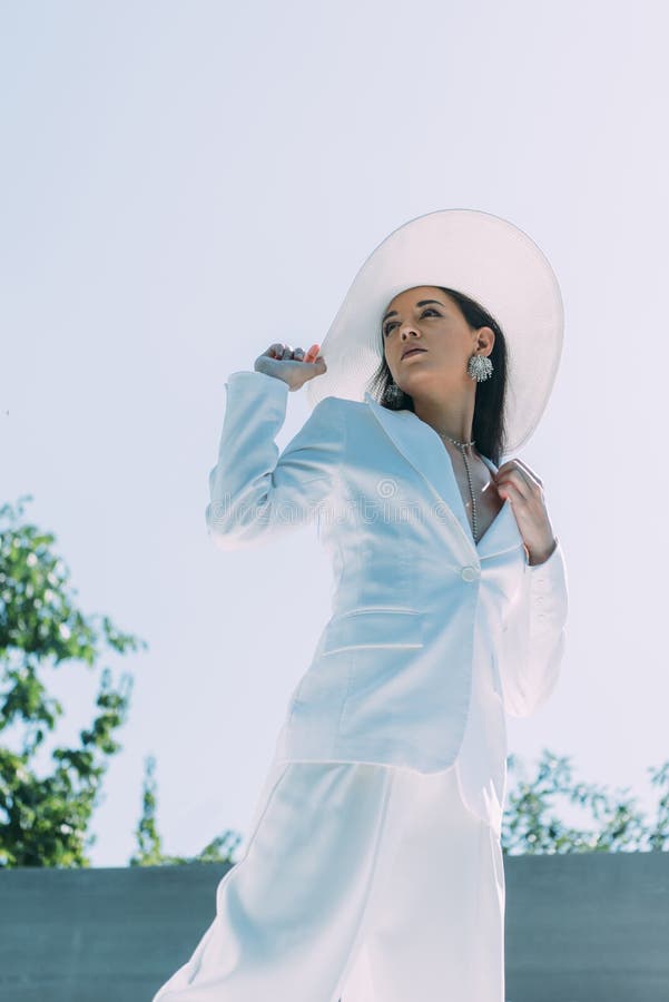 Angle View of Attractive Woman in White Suit and Hat Posing Outside ...