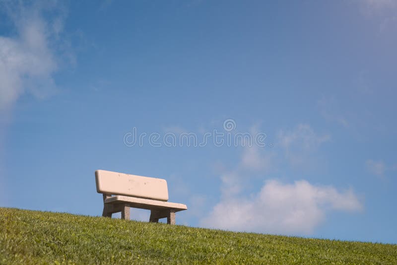 A Low-angle View of Concrete Bench on a Grassy Hill with Blue Sky ...