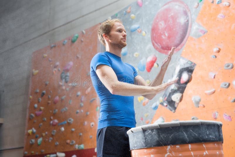 Low Angle View of Confident Man Dusting Powder by Climbing Wall in ...