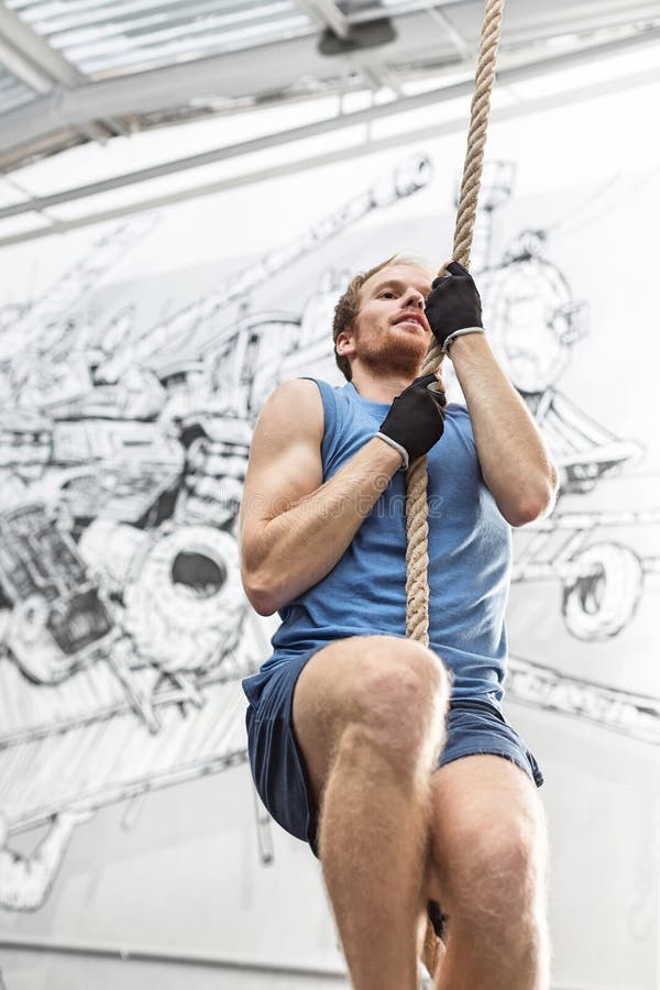 Low Angle View of Determined Man Climbing Rope in Crossfit Gym Stock ...