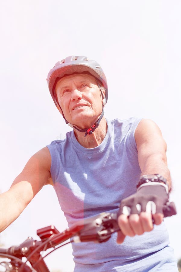Low Angle View of Determined Senior Man Cycling Against Sky Stock Image ...