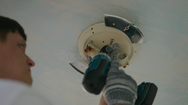 Low-angle View of Electrician Male Using Power Screwdriver To Install ...