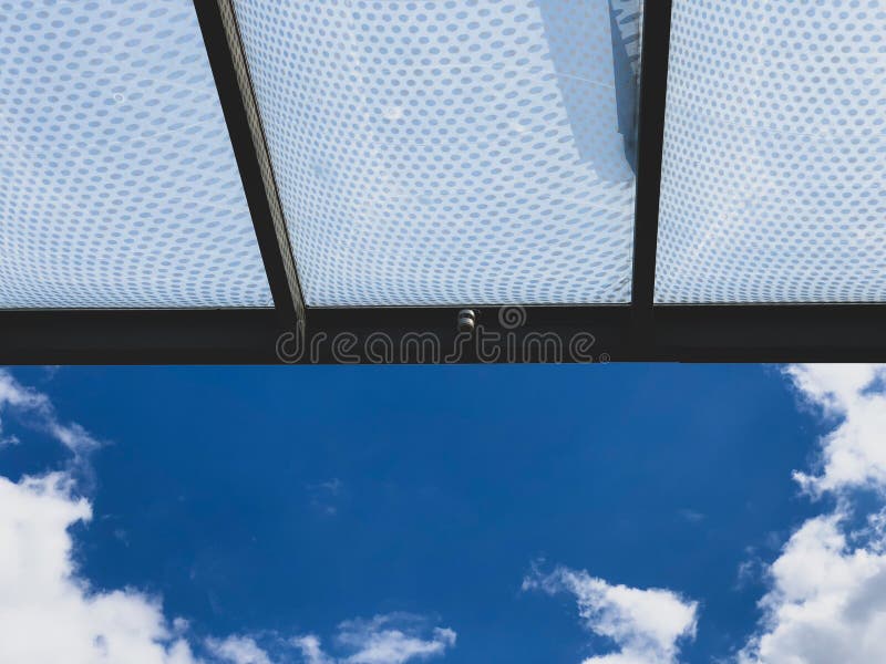 Low Angle View of Glass Ceiling with Blue Sky and White Clouds on a ...