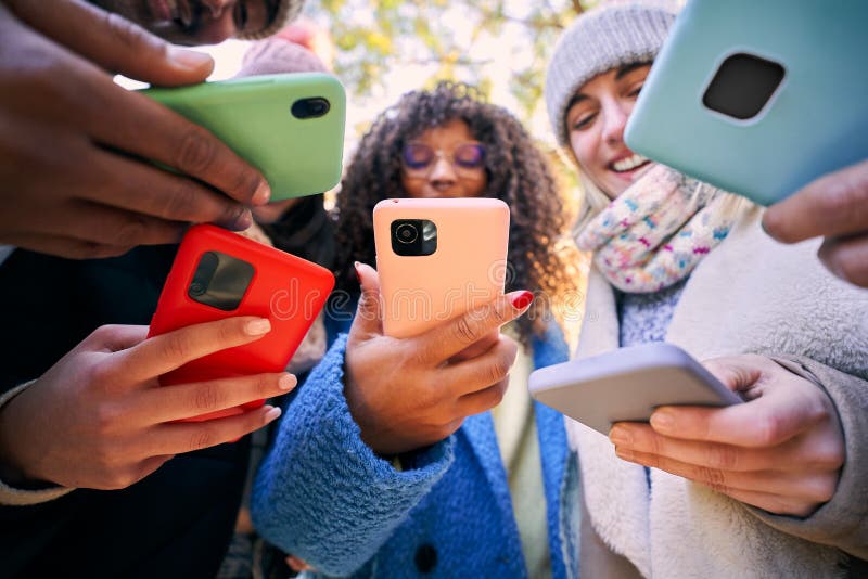 Low Angle View of a Group of Young Teenagers Using Cell Phones. Concept ...