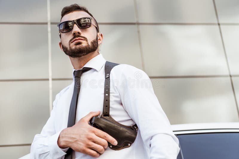 Low Angle View of Handsome Security Guard in Sunglasses Touching Gun ...