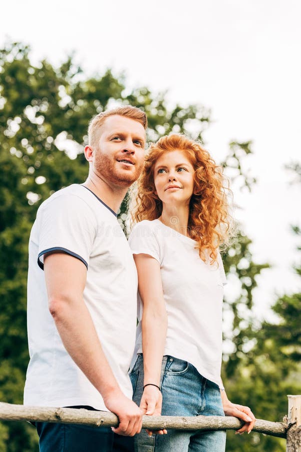 Low Angle View of Happy Redhead Couple Standing Together and Looking ...