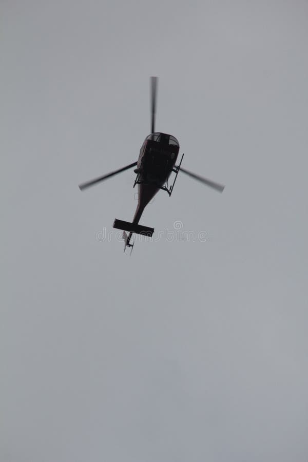 Low Angle View of a Helicopter Soaring High in the Gloomy Sky Stock ...