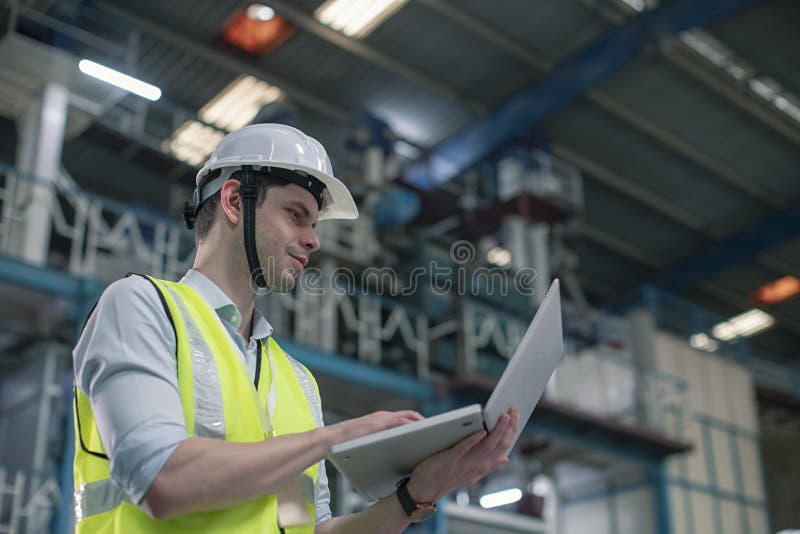 Low Angle View of a Male Technical Engineer Working on a Laptop in the ...
