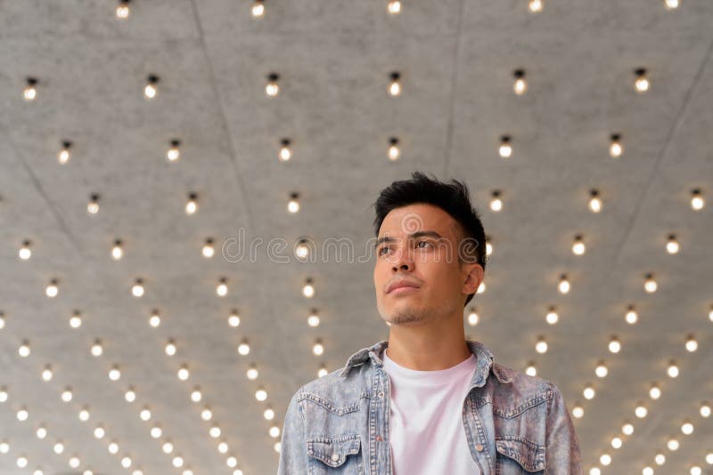 Low Angle View Portrait of Handsome Young Man Thinking Outdoors in City ...