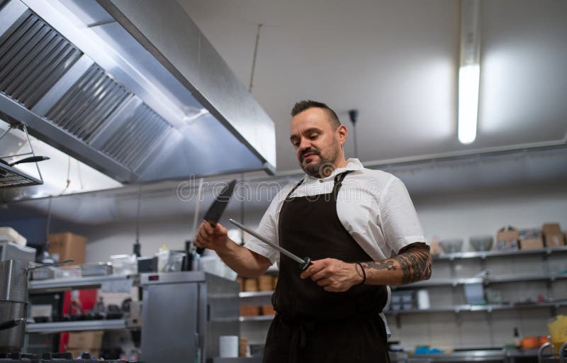 Low Angle View of Professional Chef Sharpening Knife in Restaurant ...