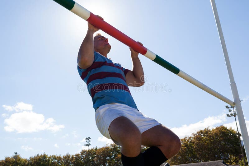 Low Angle View of Rugby Player Exercising on Goal Post Against Sky ...