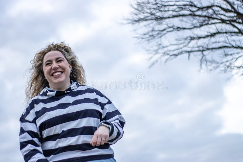 Smiling Woman Walking with Sky in Background. Bottom View of Smiling ...