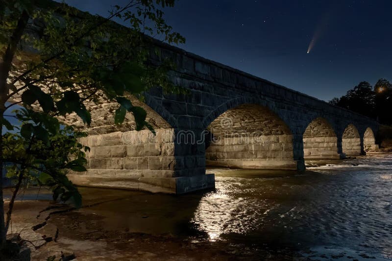 Low Angle View of a Stone Bridge with a Comet Visible Passing in the ...