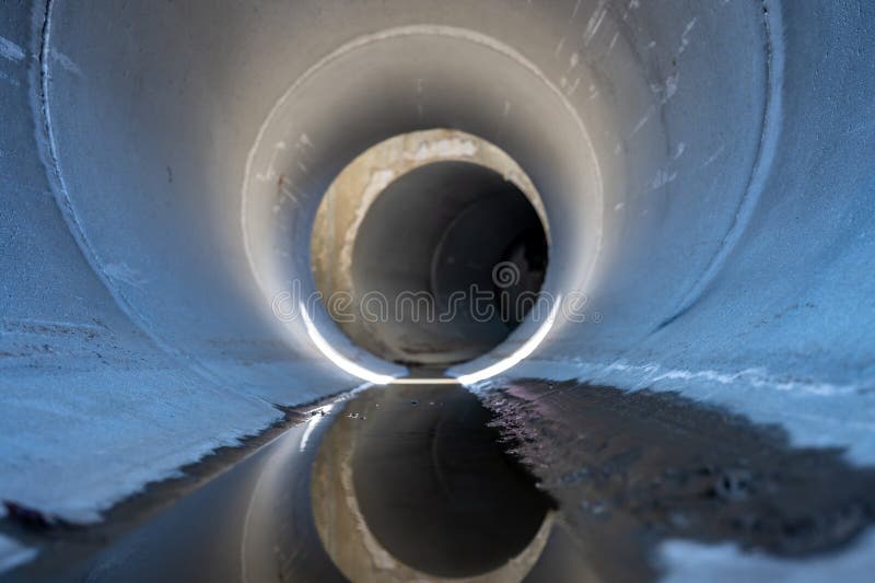 Low Angle View of Stormwater Trickling through a Large Concrete Culvert ...