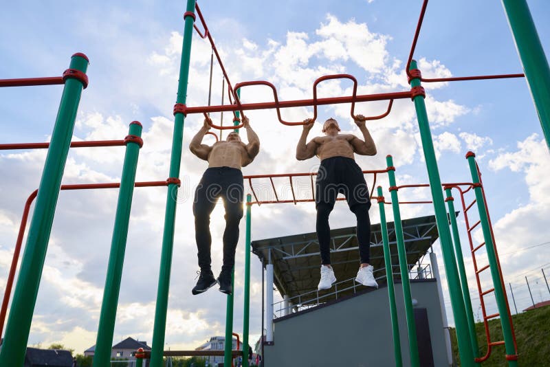 Strong Men Doing Exercises for Arms on Sports Ground Stock Image ...