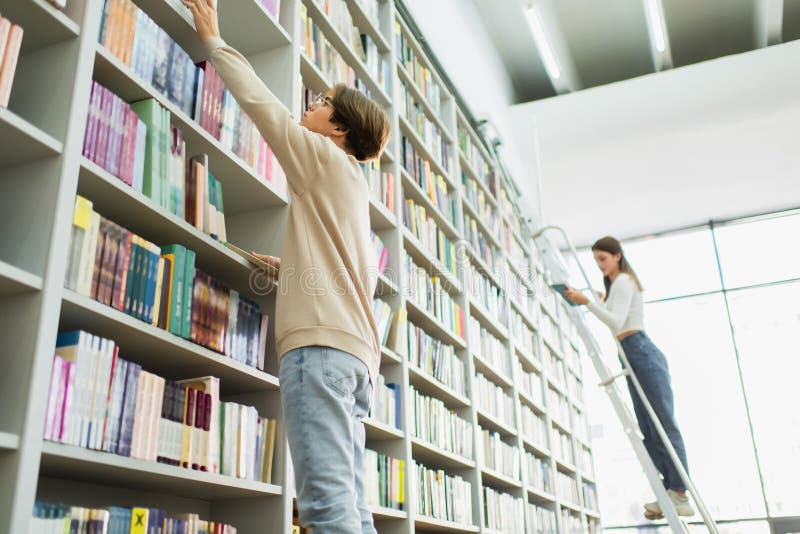 Low Angle View of Students Choosing Stock Photo - Image of shelves ...