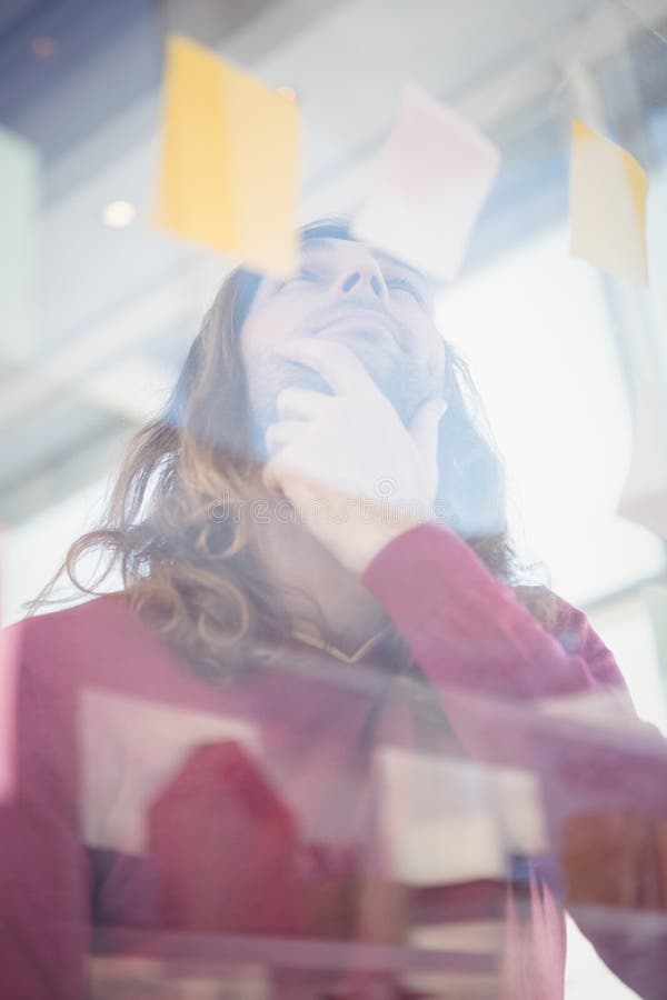 Low Angle View of Thoughtful Businessman Looking at Sticky Note Stock ...