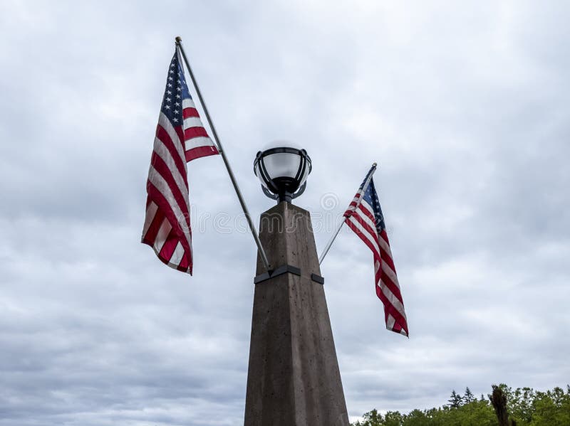 View of Two American Flags Attached To a Lamp Post Against a Cloudy ...