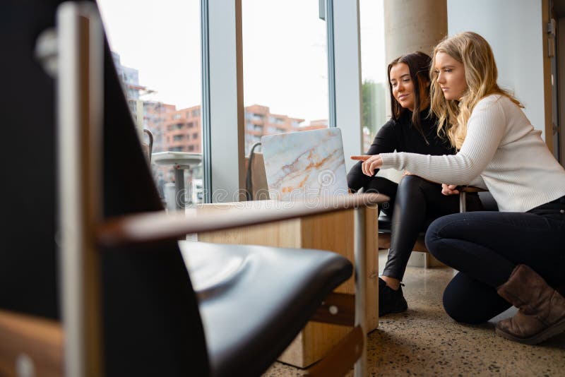 Two Women Working Together with Project on Laptop at Cafe Stock Photo ...