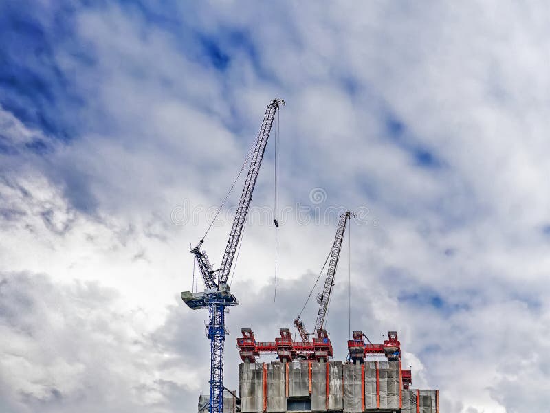 Under Construction Building with Cranes Against Cloudy Sky Stock Image ...