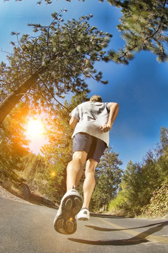 Low Angle View of Young Man Jogging on Road Stock Image - Image of ...
