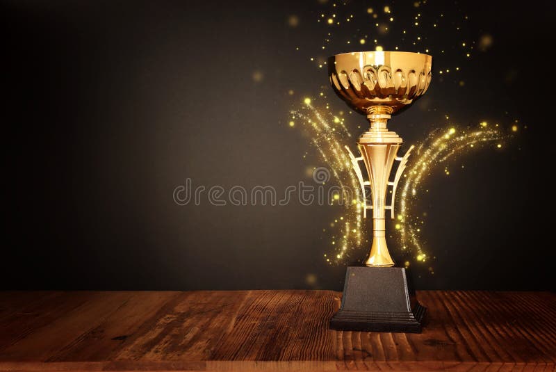 Low Key Image of Gold Trophy Over Wooden Table and Dark Background ...