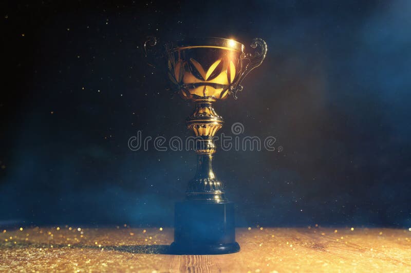 Low Key Image of Trophy Over Wooden Table and Dark Background, with ...