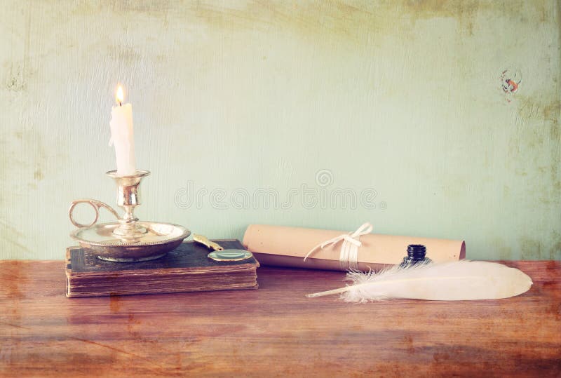 Low Key Image of White Feather, Inkwell and Candle on Old Wooden Table ...