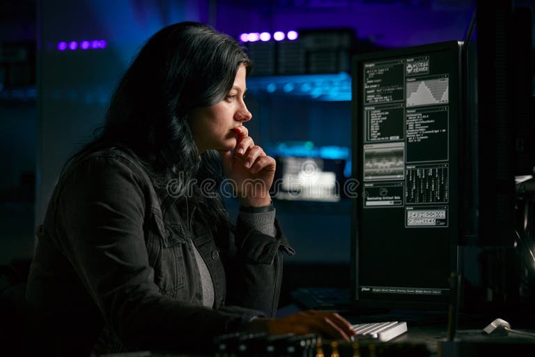 Low Key Lighting Shot of Female Computer Hacker Sitting in Front of ...