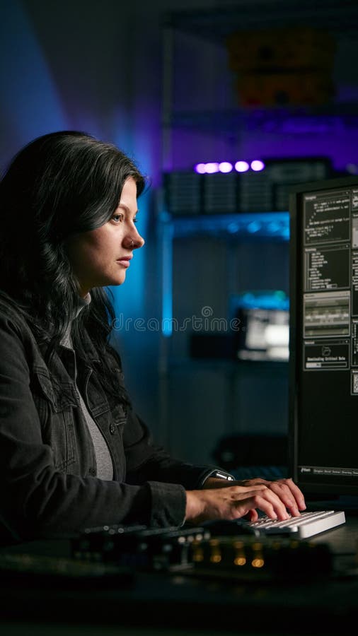 Low Key Lighting Shot of Female Computer Hacker Sitting in Front of ...