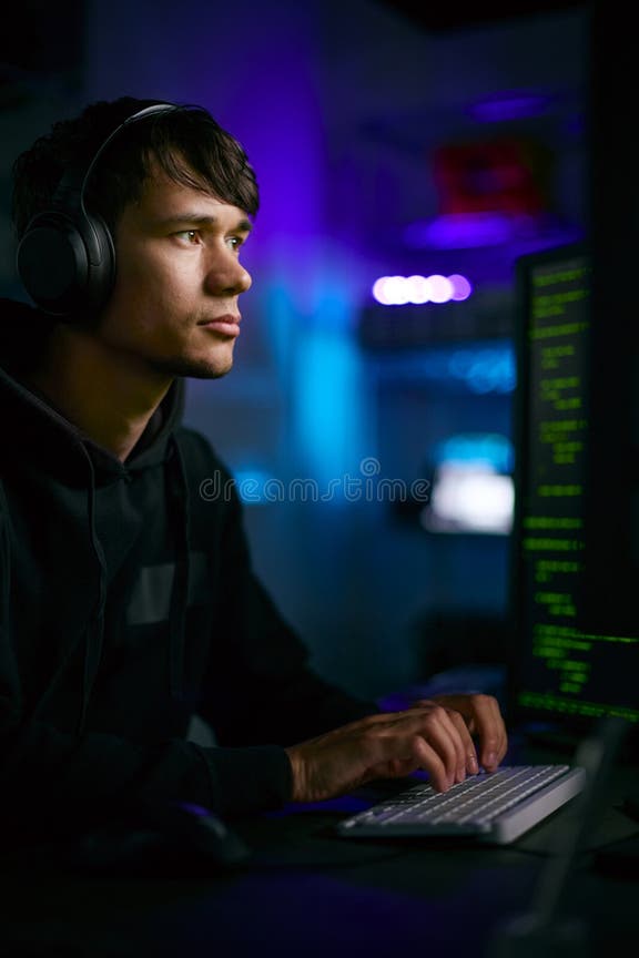Low Key Lighting Shot of Male Computer Hacker Sitting in Front of ...