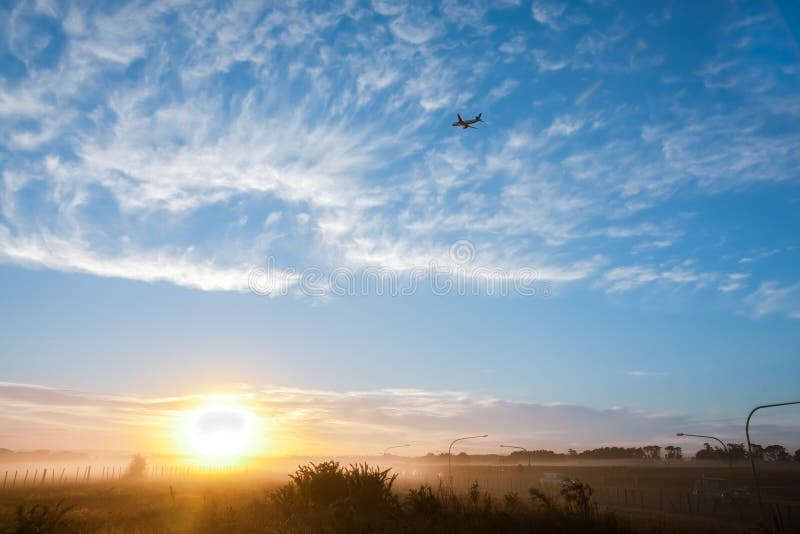 Low Mist at Sunrise while Passenger Plane Flys High Overhead Stock ...