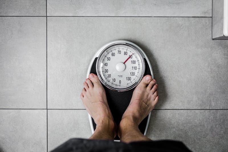 Low Section of Man Standing on Weight Scale Stock Photo - Image of feet ...
