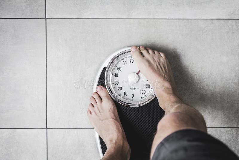 Low Section of Man Standing on Weight Scale Stock Image - Image of ...