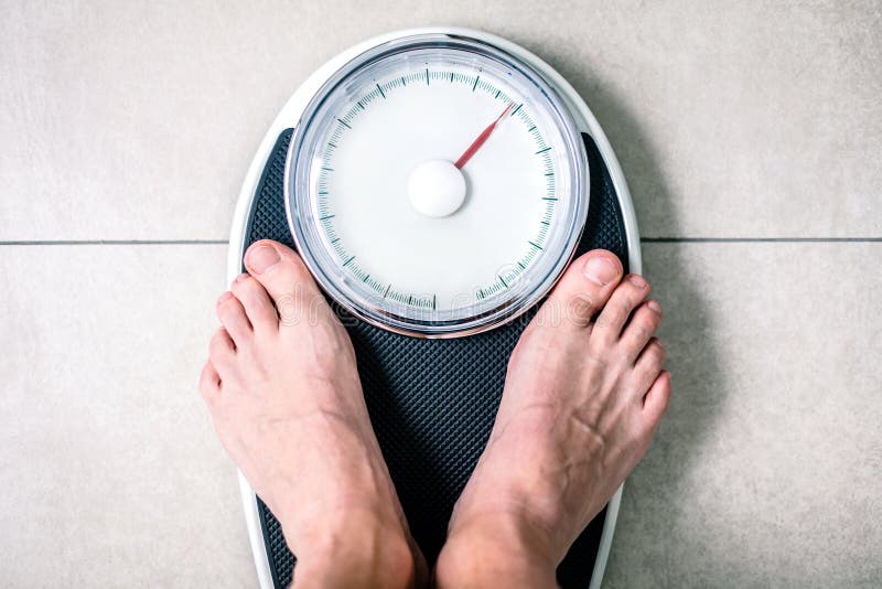 Low Section of Man Standing on Weight Scale Stock Image - Image of ...