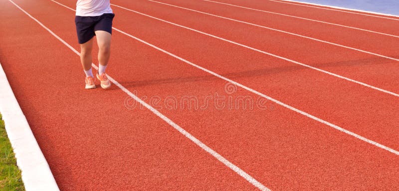 Low Section of Young Man Jogging on Running Track in Outdoors Stadium ...
