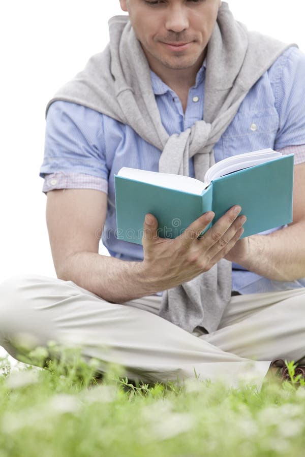 Low Section of Young Man Reading Book on Grass Stock Image - Image of ...
