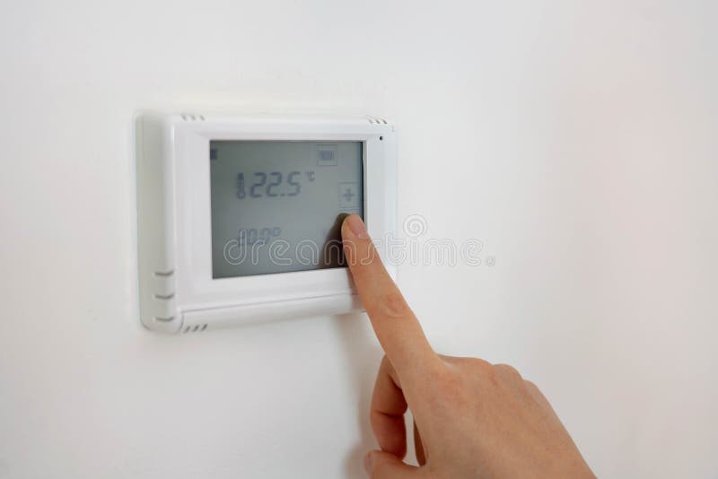 Lowering the Temperature for Energy Saving. Human Hand Adjusting ...