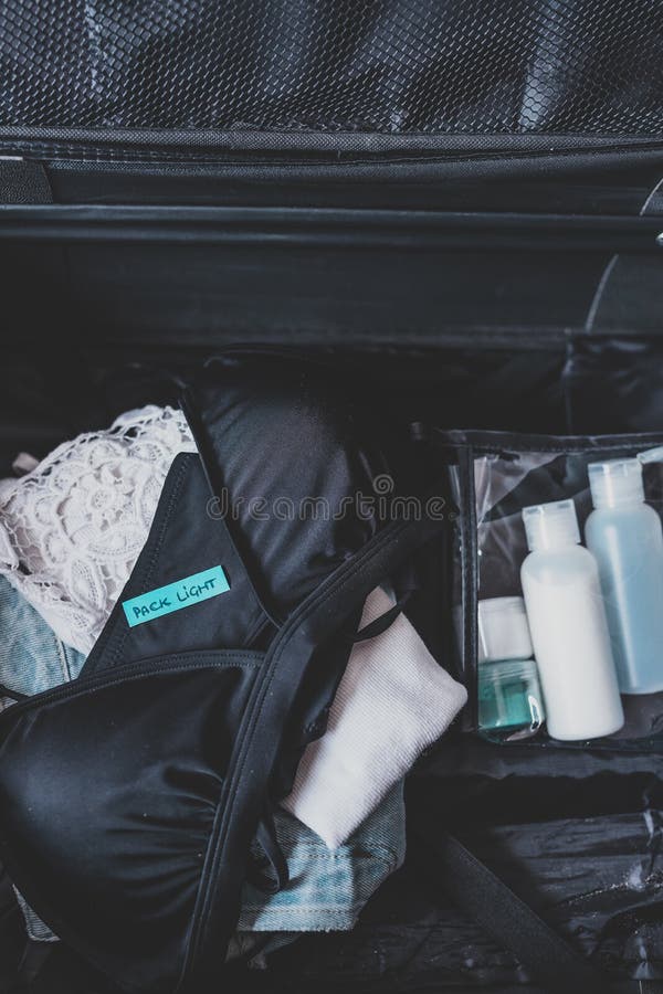 Luggage with Few Items Inside and Packing Light Label on Them Stock ...