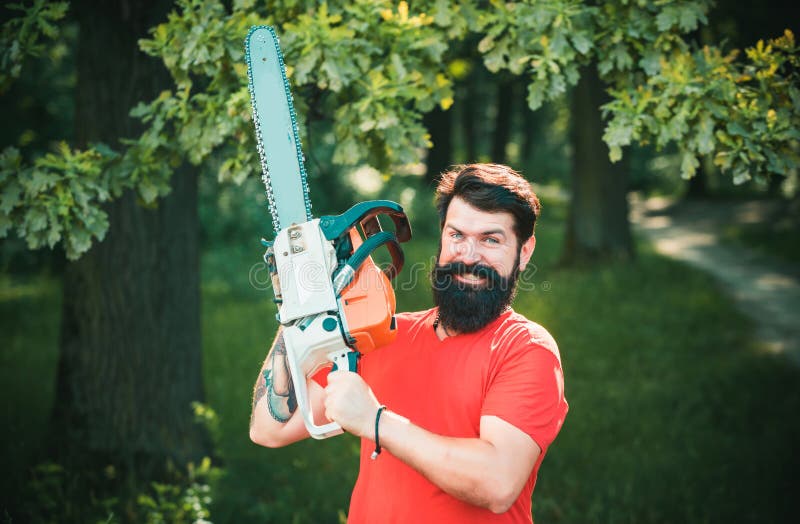 Lumberjack in the Woods with Chainsaw Axe. Handsome Young Man with Axe ...