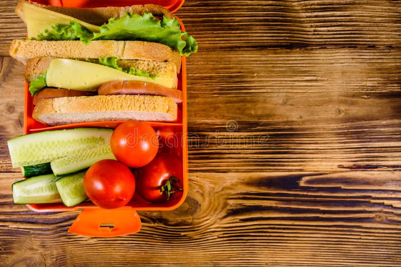 Lunch Box with Sandwiches, Cucumbers and Tomatoes on Wooden Table. Top ...