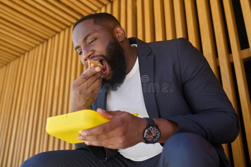 A Man Sitting on the Bench and Having Lunch Stock Image - Image of ...