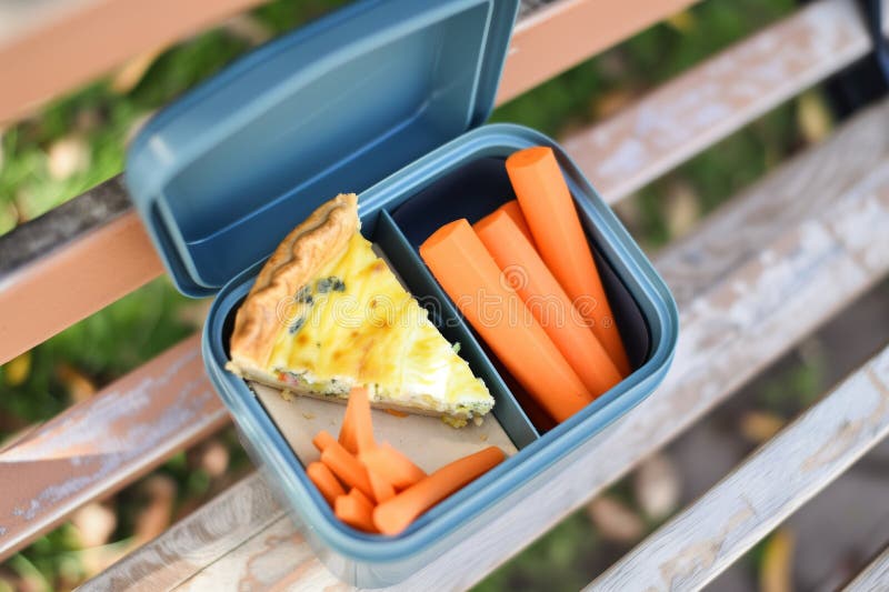 Lunchbox with Quiche Slice and Carrot Sticks on Bench Stock Photo ...