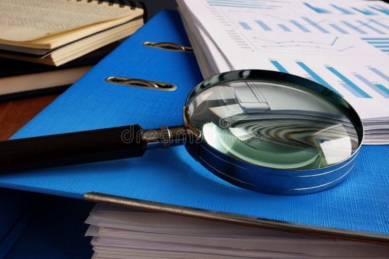 Lupa Y Carpeta Con La Pila De Documentos De Negocio Foto de archivo ...