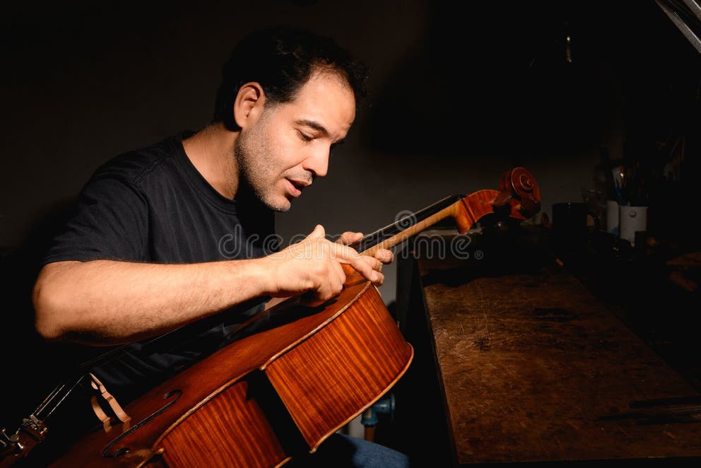 Luthier with a cello stock photo. Image of instrument - 338543474