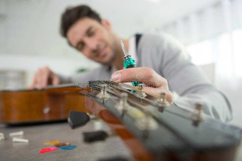 Luthier Using Screwdriver To Work on Guitar Stock Photo - Image of hand ...